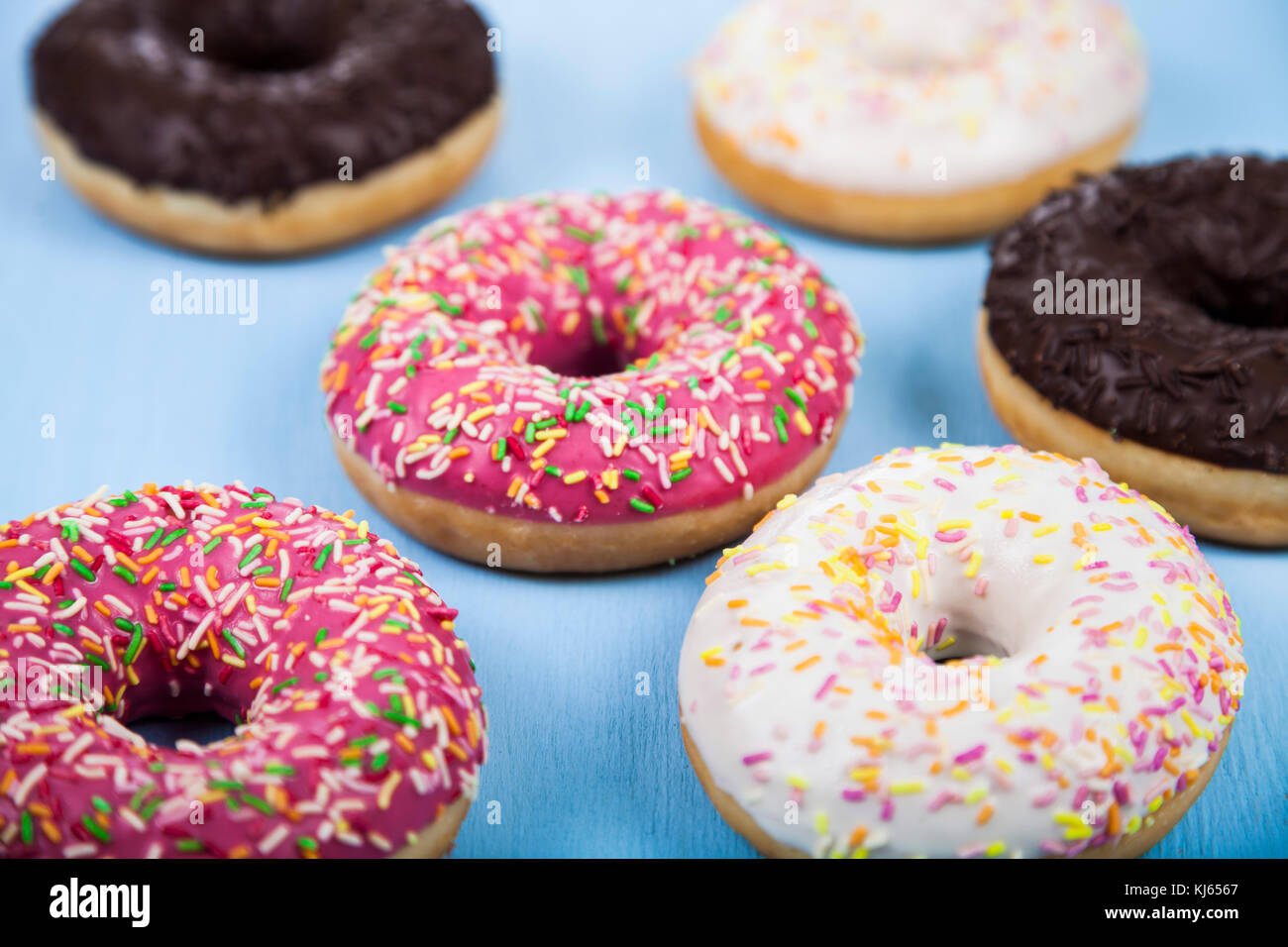 Multicolored donuts close-up on a wooden background. Delicious dessert ...