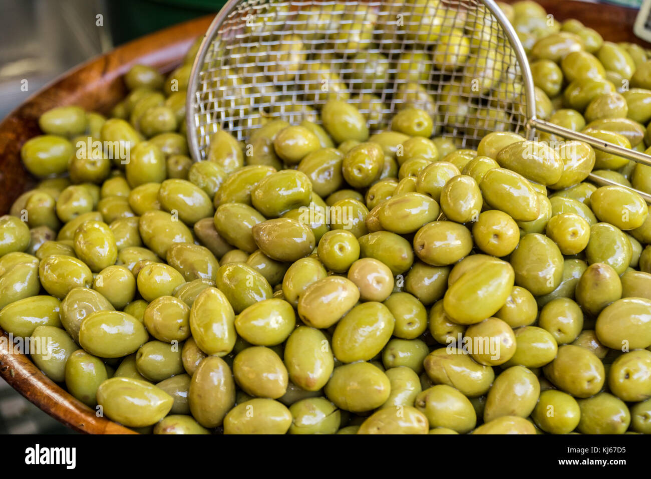 Whole green table olives in the bowl. Close-up Stock Photo - Alamy