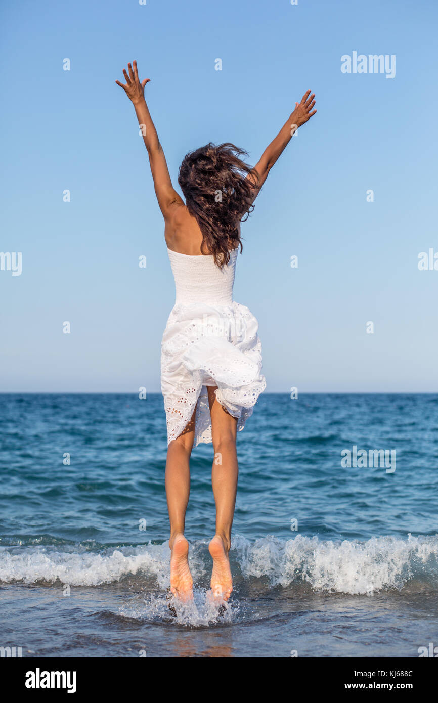Woman jumping in the sea water Stock Photo - Alamy