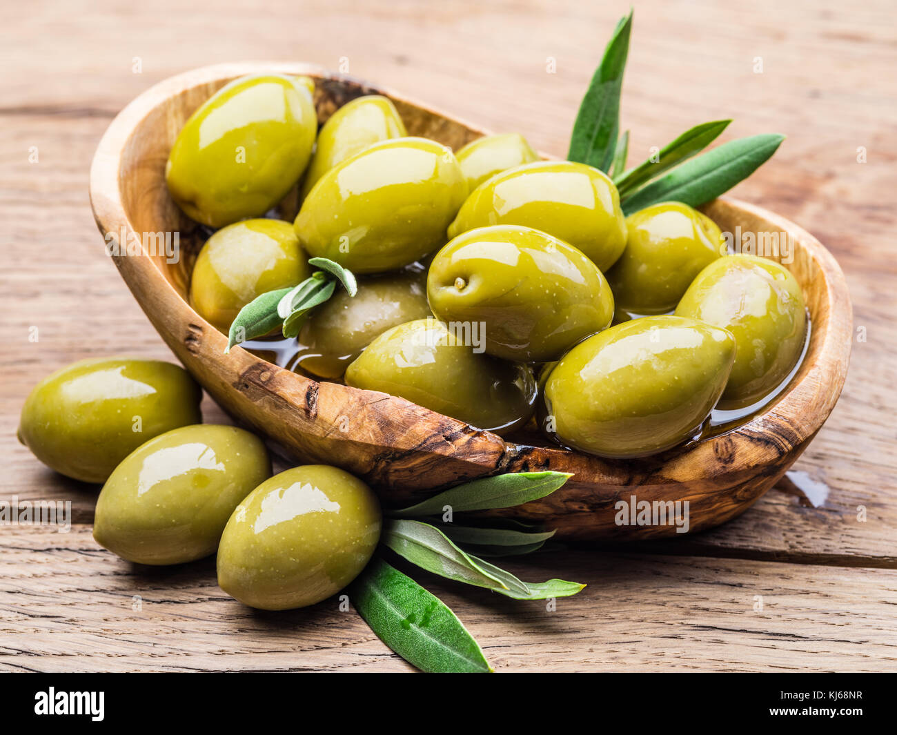 Whole table olives in the wooden bowl on the table Stock Photo - Alamy