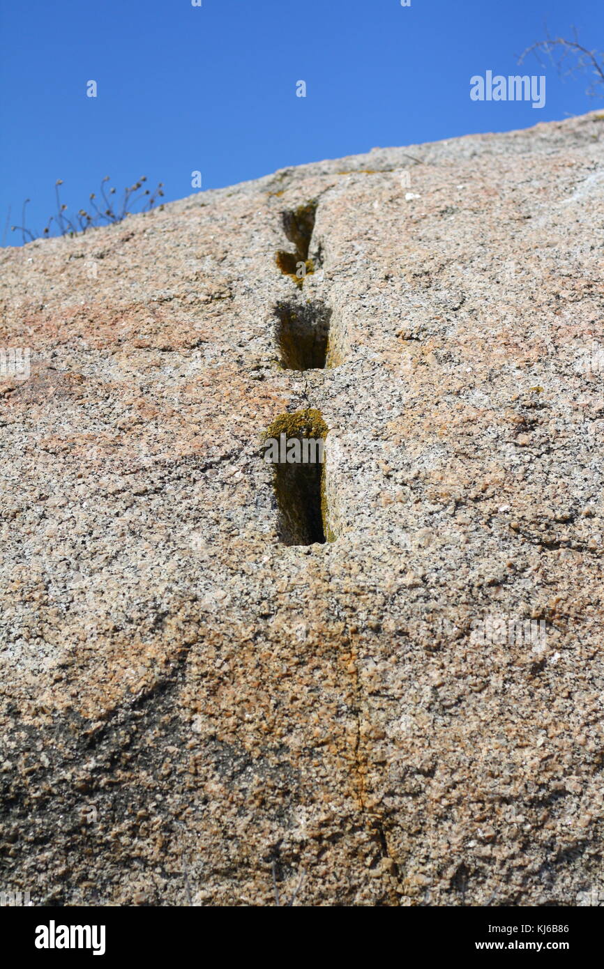 A stone granite rock with drilled holes to break it Stock Photo - Alamy