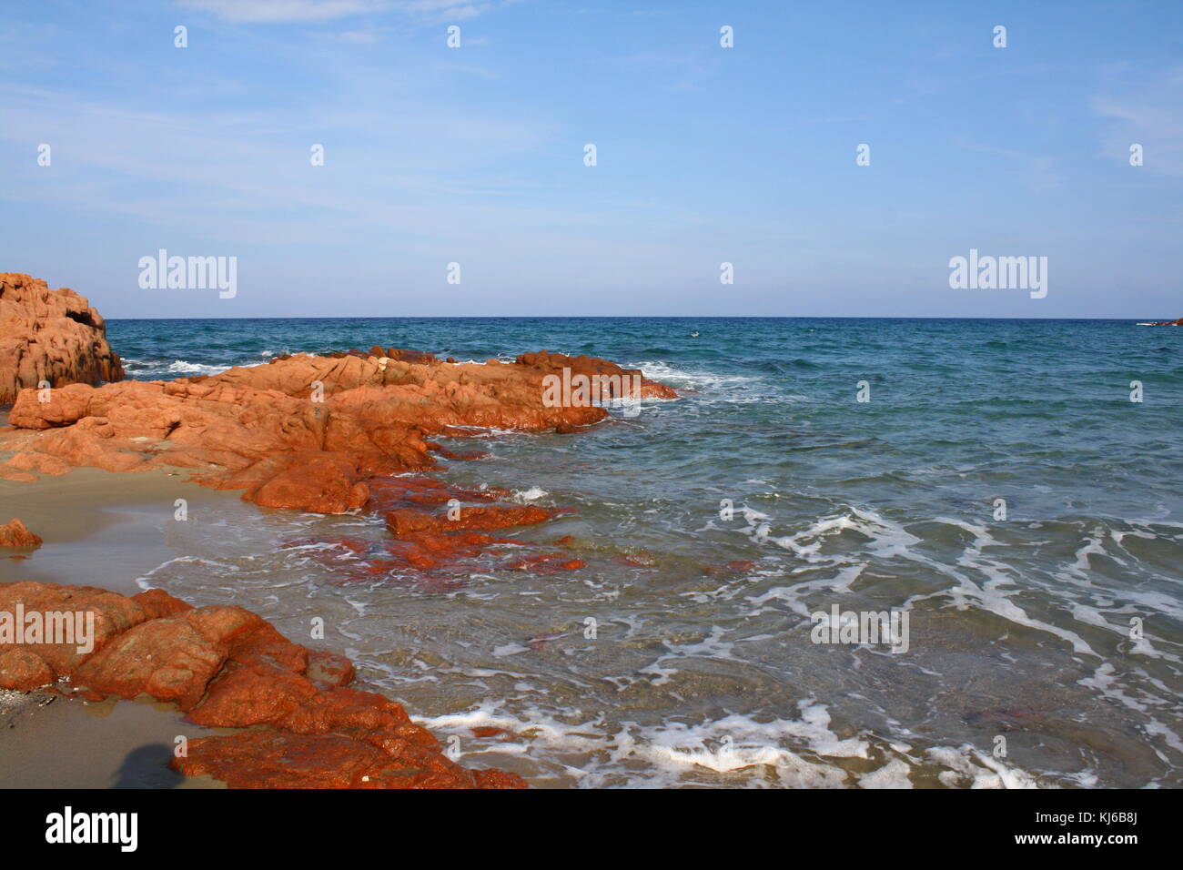 Waves coming in hard on the rocks and stones of a rigid beach seaside ...