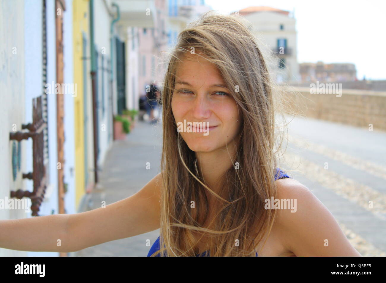 A young thin beautiful woman looks in the camera and shows her face in ...
