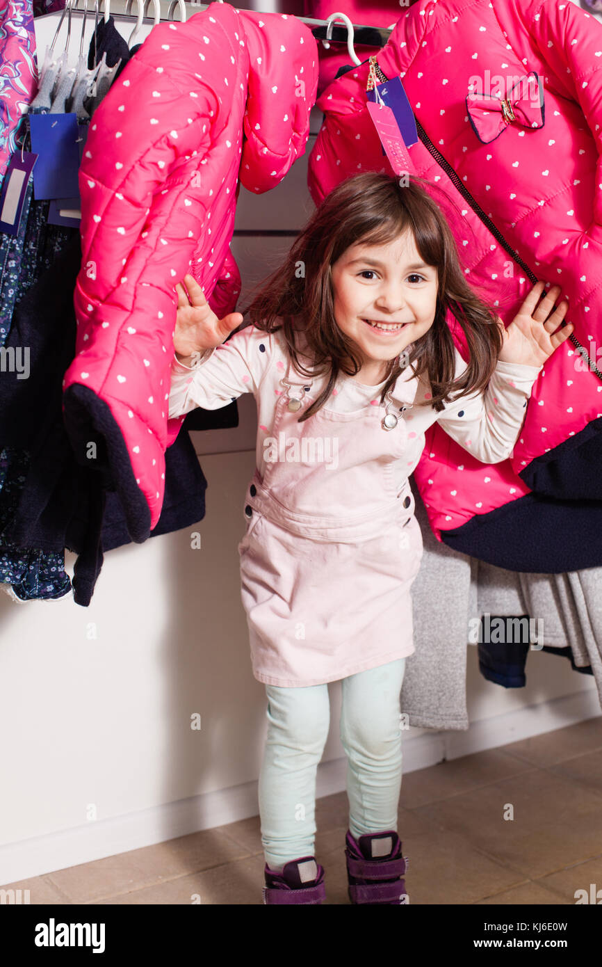 The little girl having fun in clothing store Stock Photo - Alamy