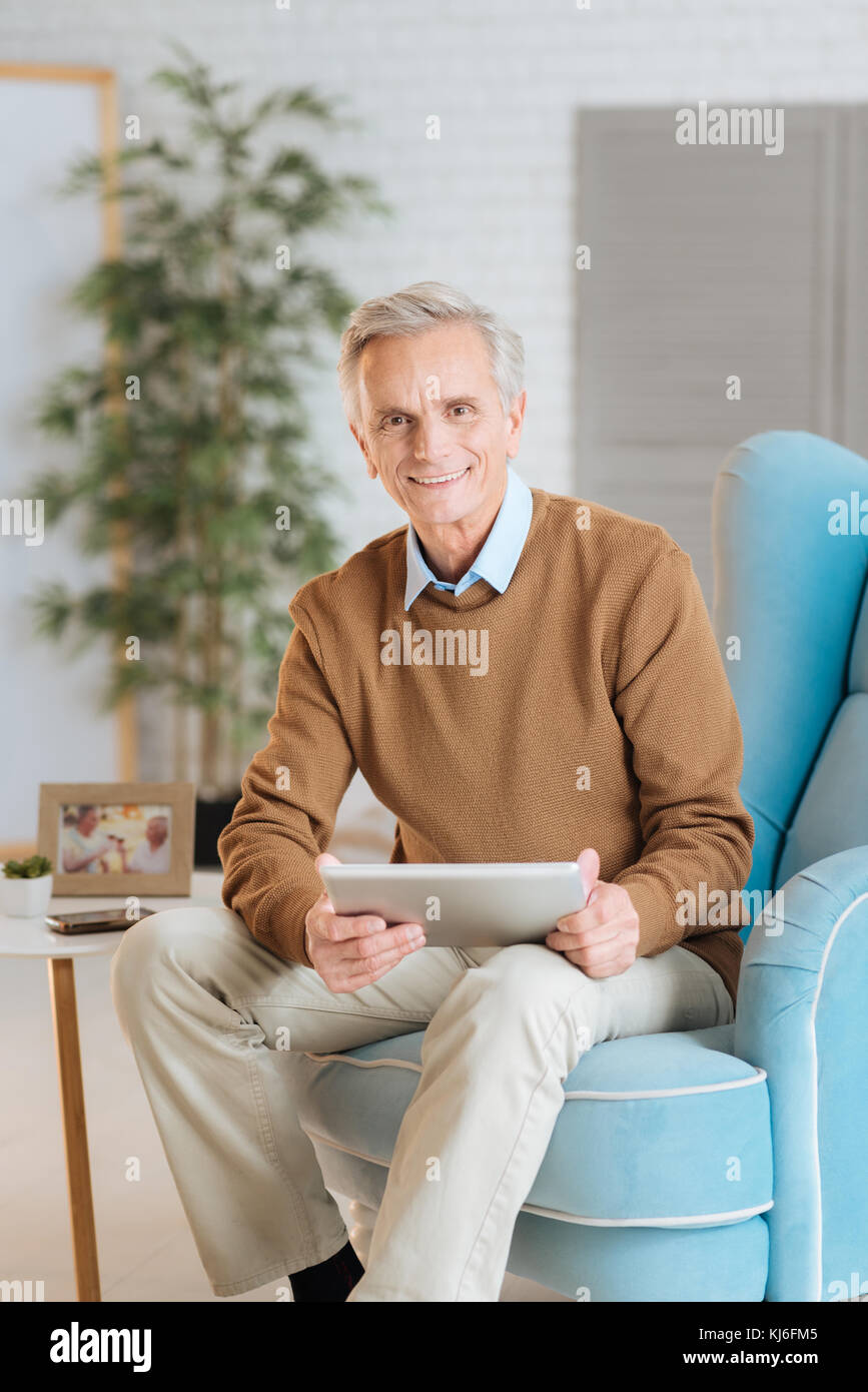 Friendly looking old gentleman working on tablet computer Stock Photo ...
