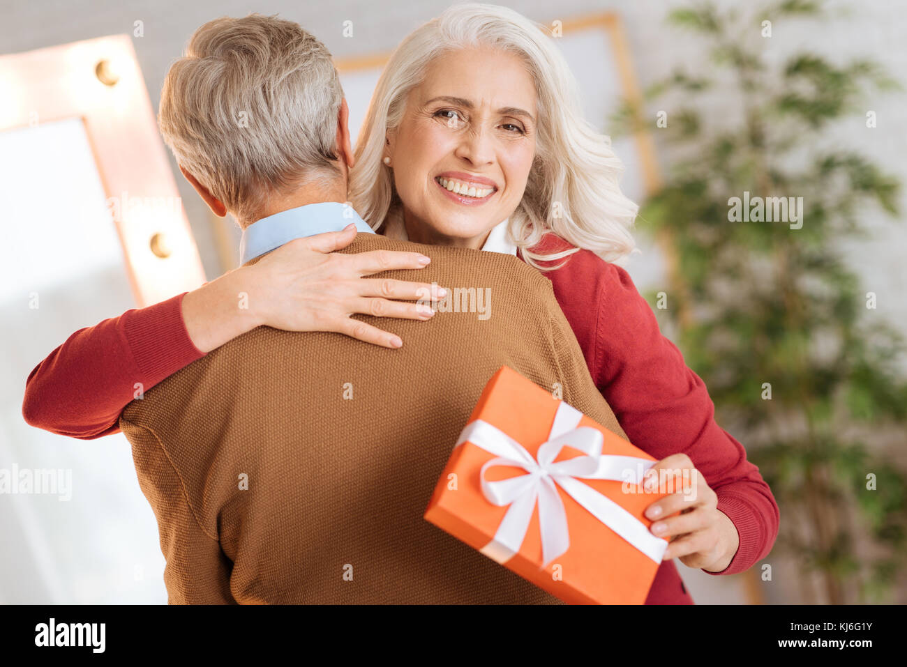 Radiant lady grinning broadly and hugging her husband Stock Photo - Alamy