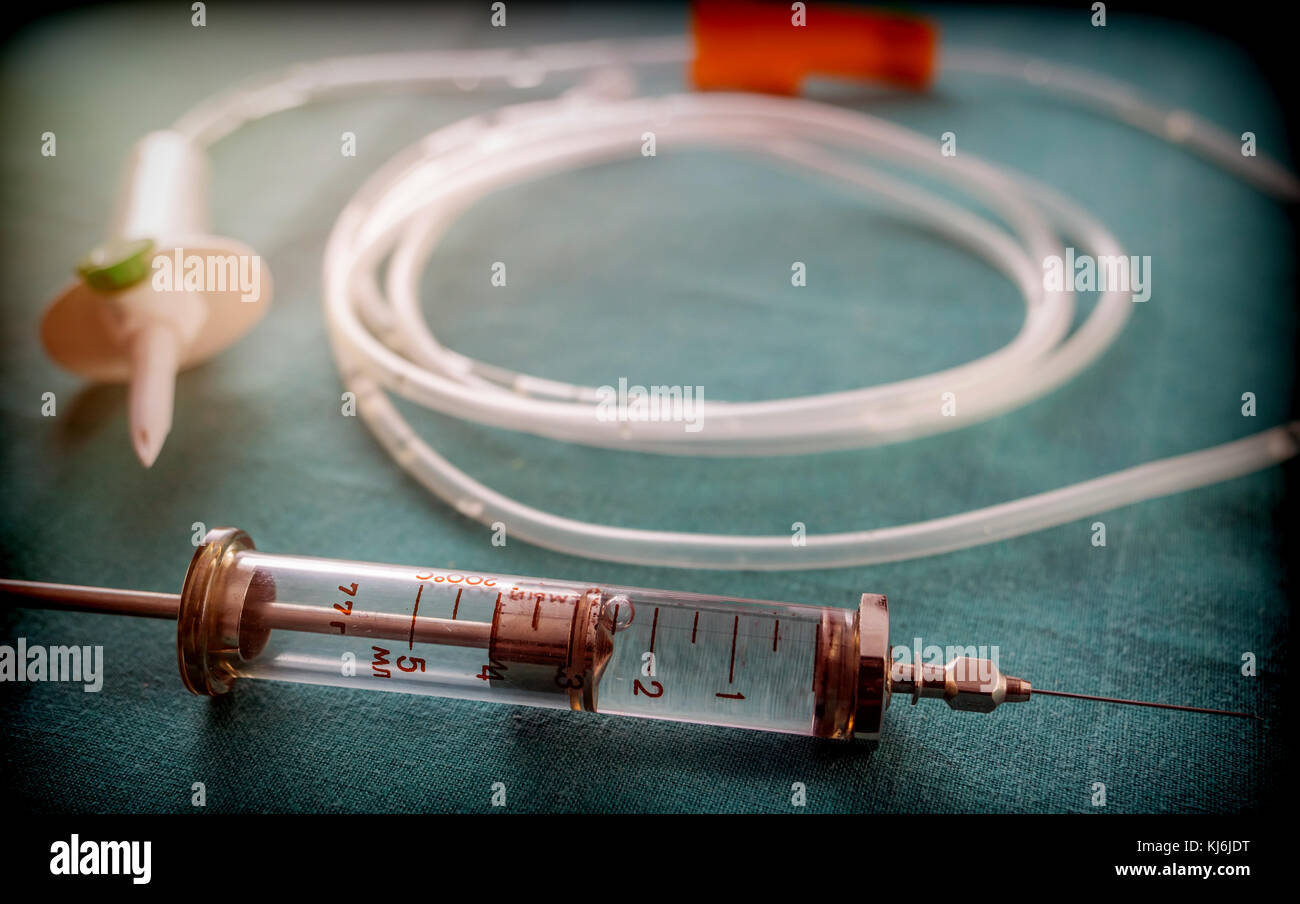Vintage syringe next to drip irrigation equipment in a hospital ...