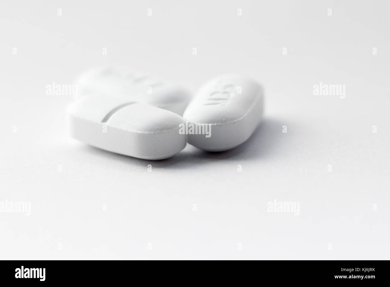 close up of a group of white tablets isolated on a white background ...