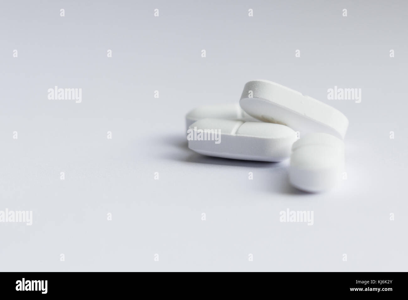 close up of a group of white tablets isolated on a white background ...