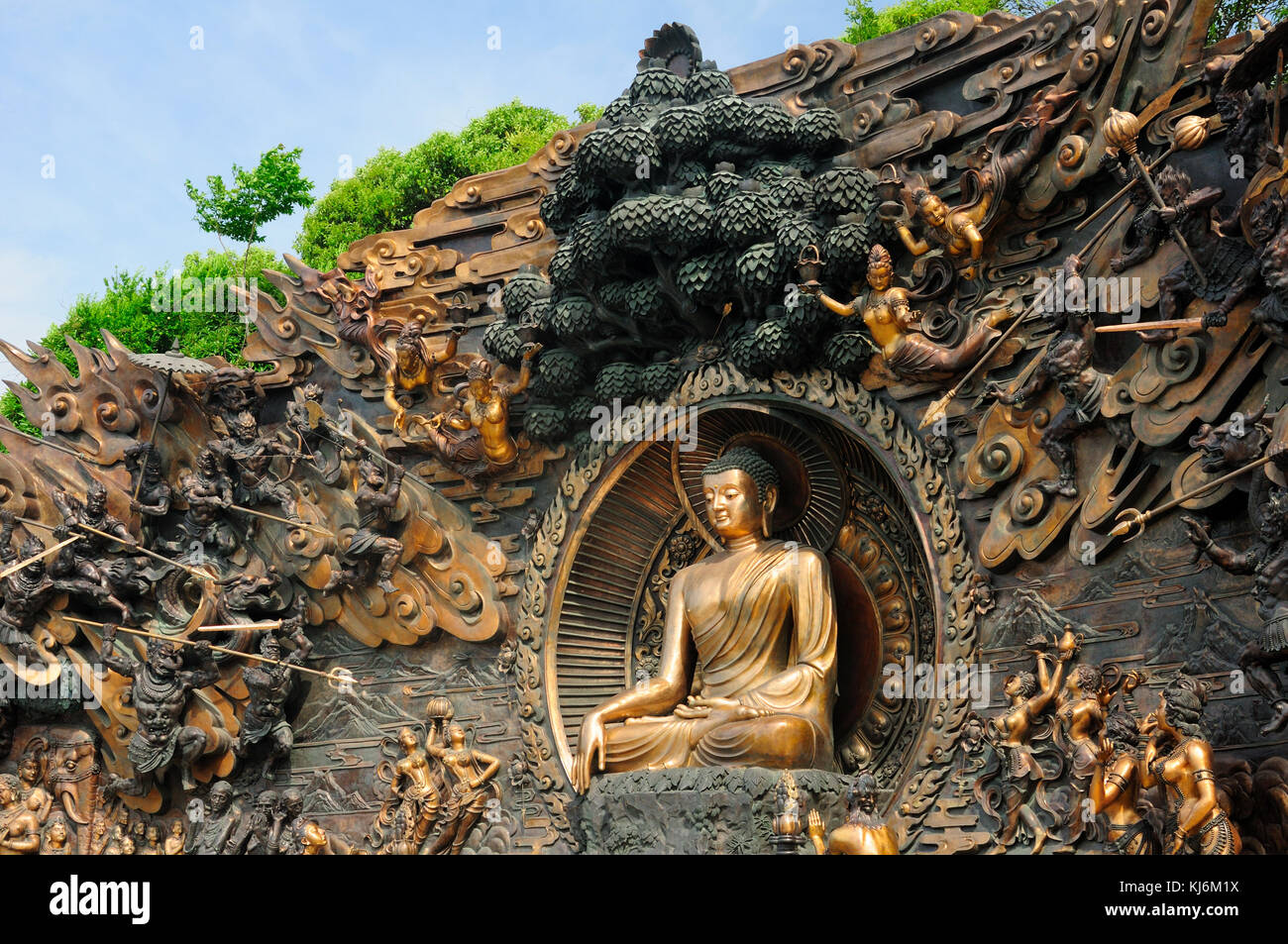 A large metal mural depicting many different Buddhist scenes at the ...