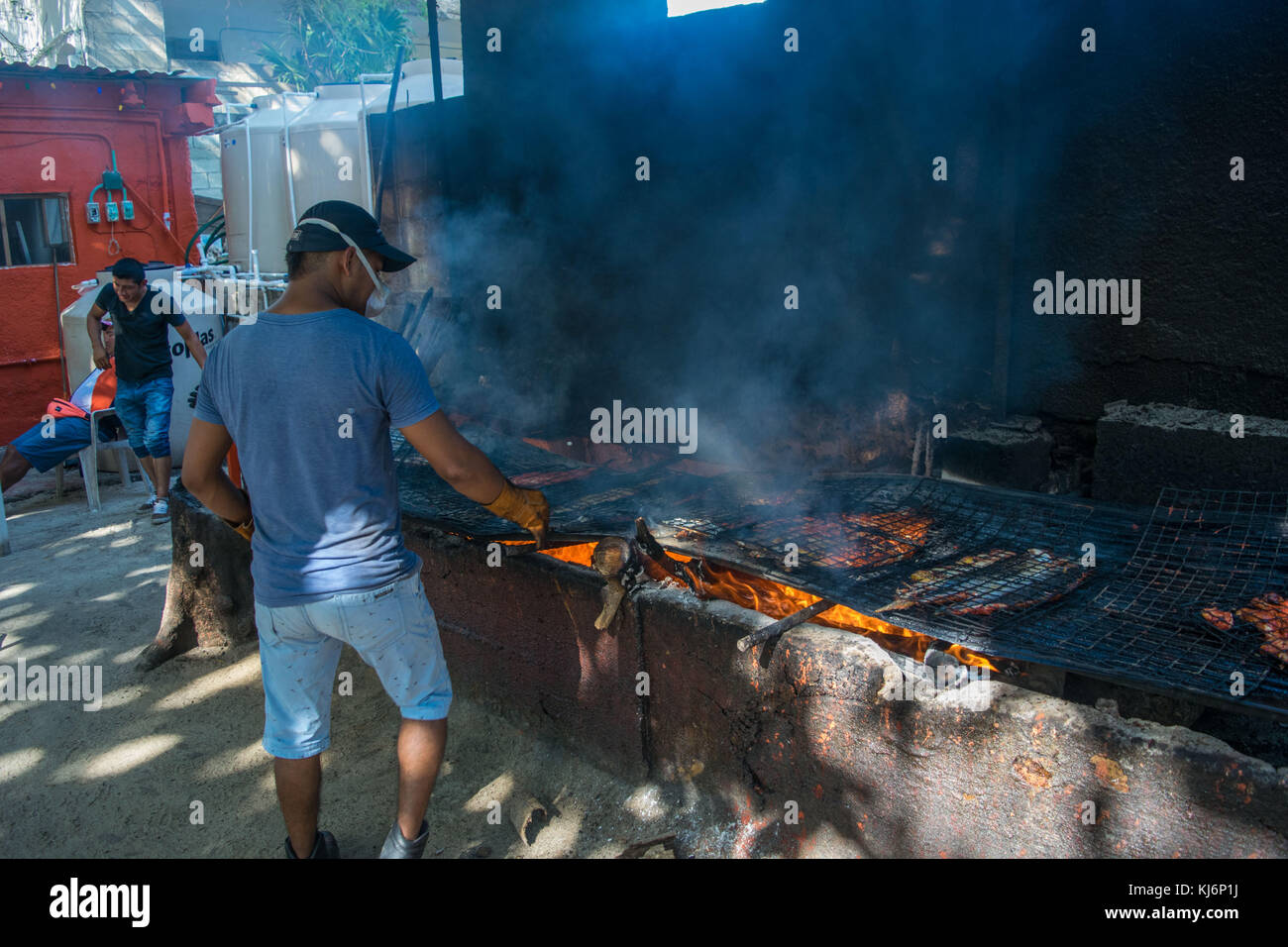 Man grilling fish Stock Photo - Alamy