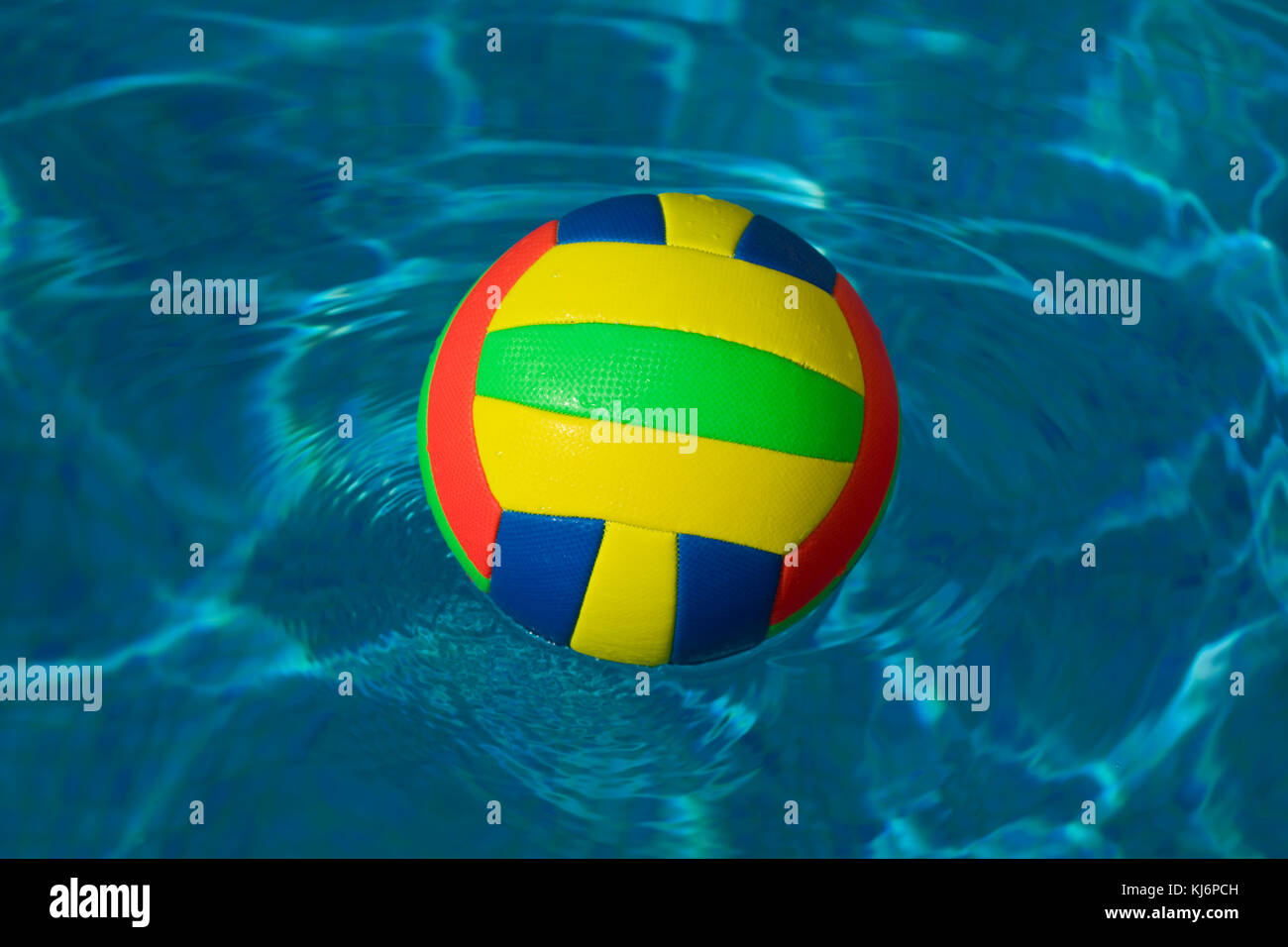 A brightly coloured football floating in a swimming pool, Spain Stock ...