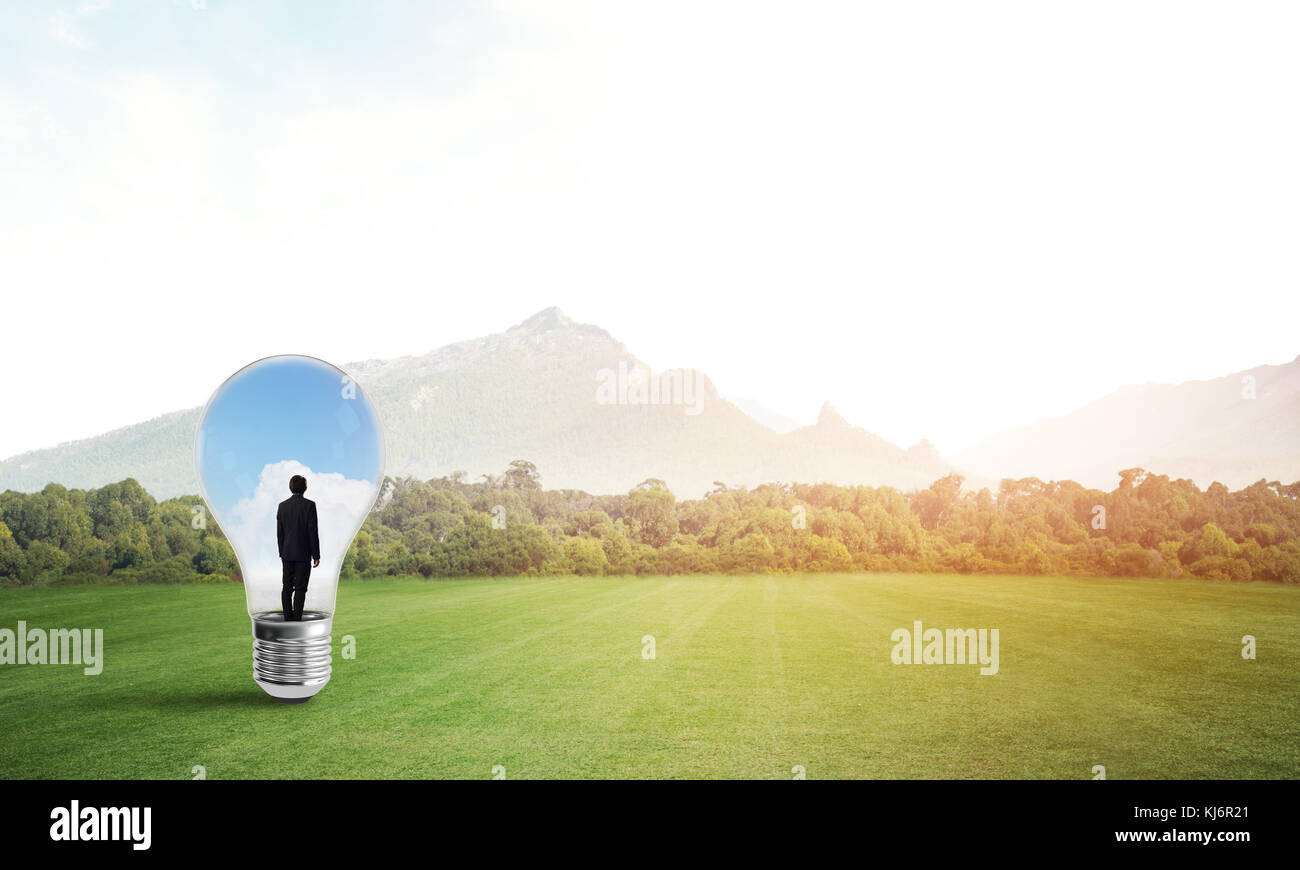 Businessman inside light bulb Stock Photo - Alamy