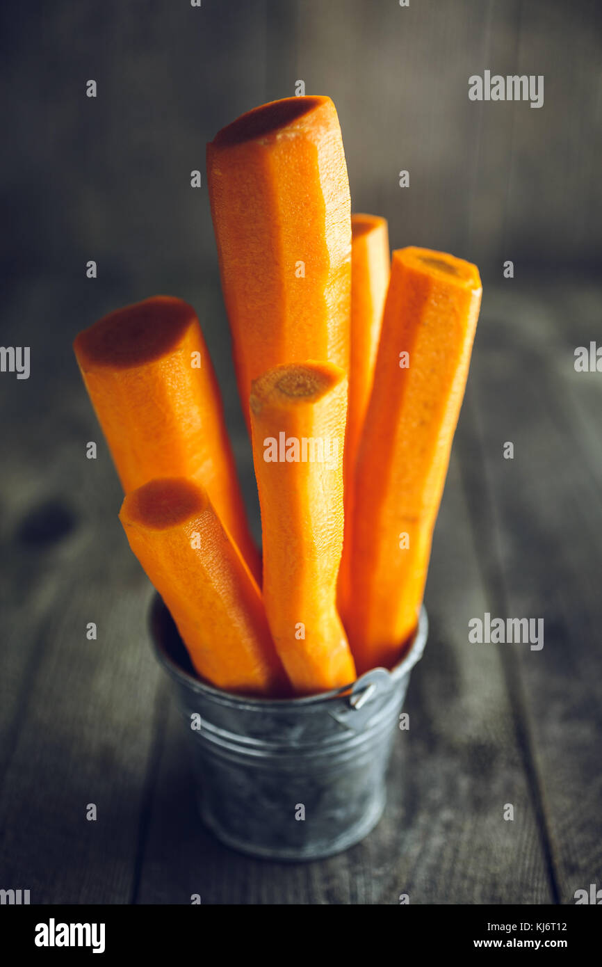 Fresh peeled carrots in iron bucket on a wooden table, soft focus Stock ...