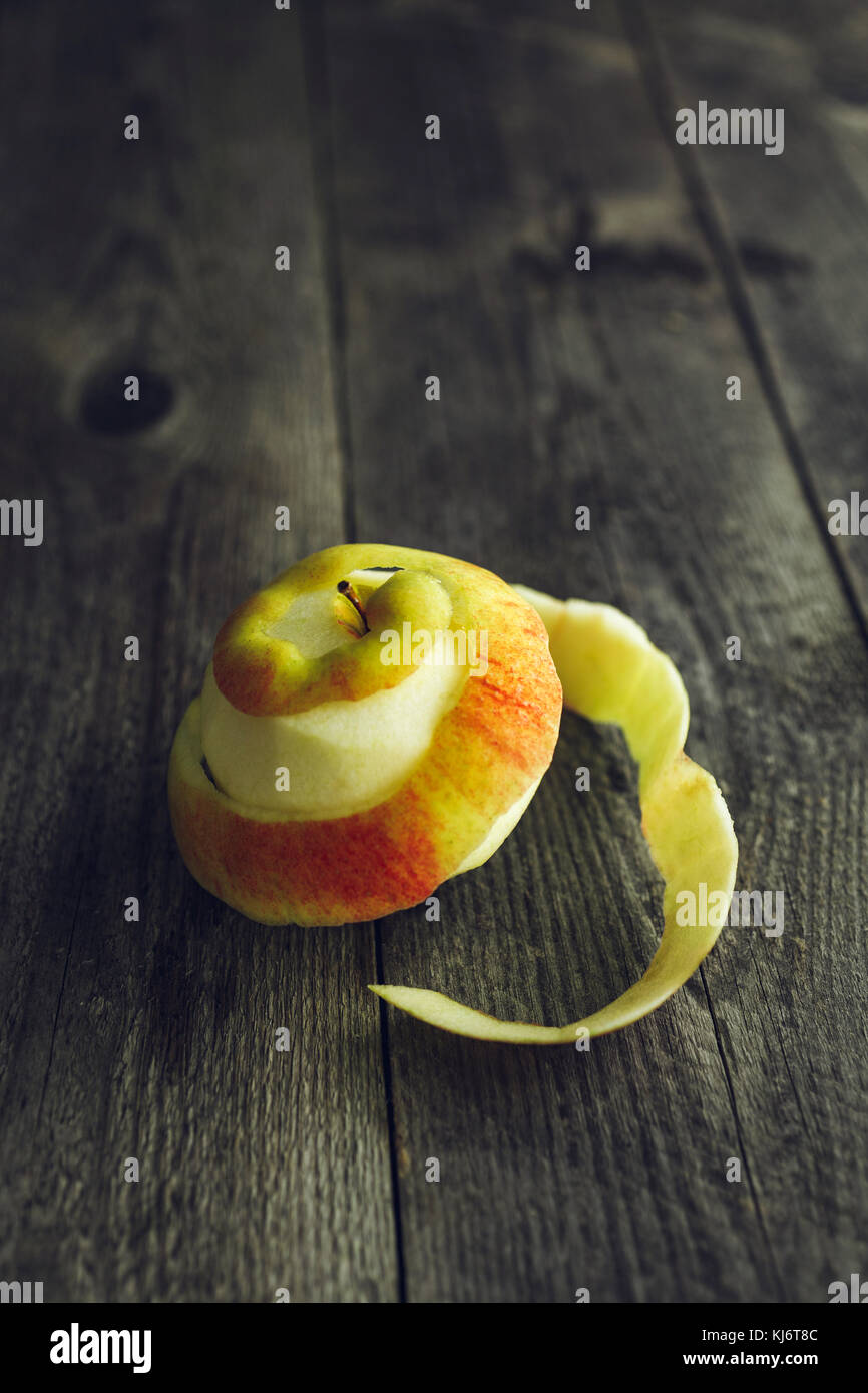 Apple with peeled skin on wooden background Stock Photo - Alamy