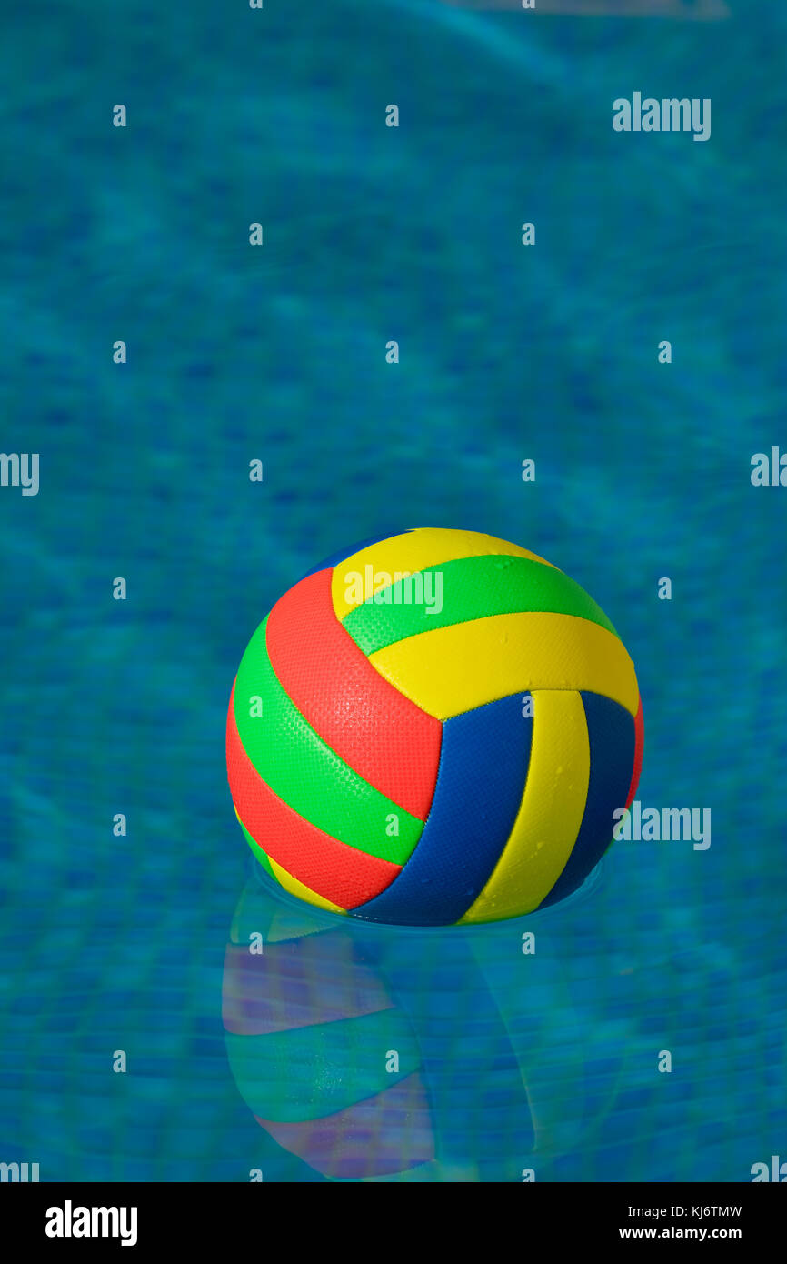 A brightly coloured football floating in a swimming pool, Spain Stock ...