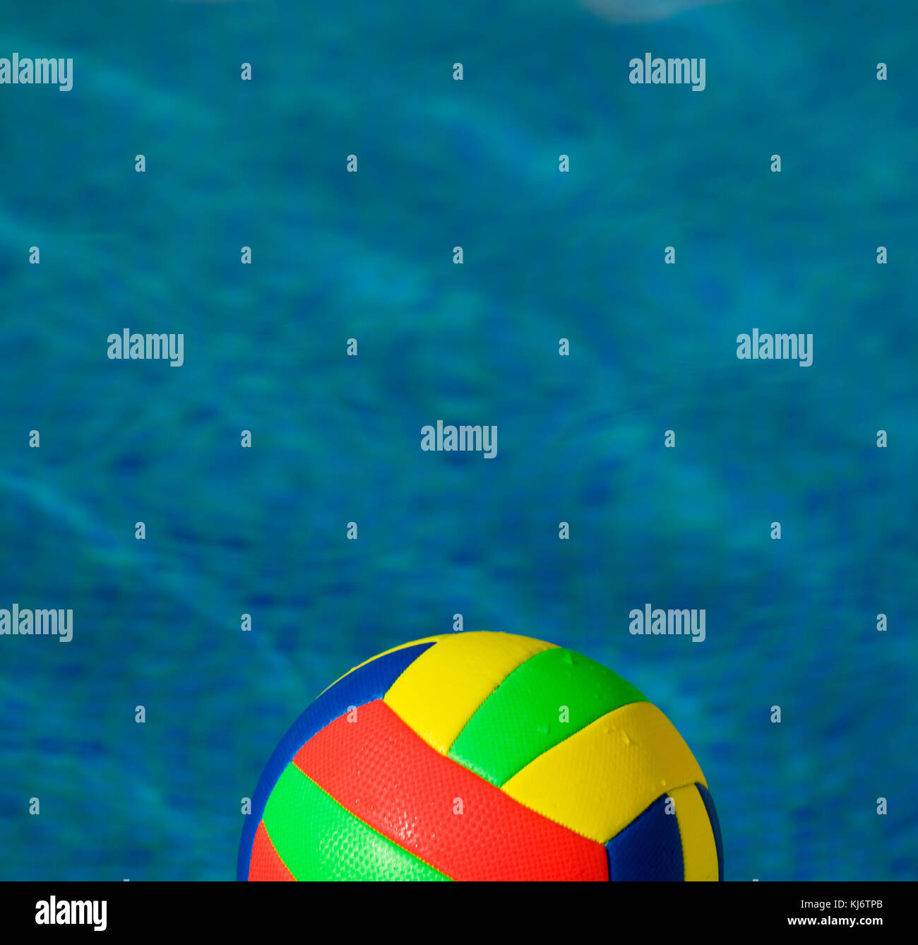 A brightly coloured football floating in a swimming pool, Spain Stock ...