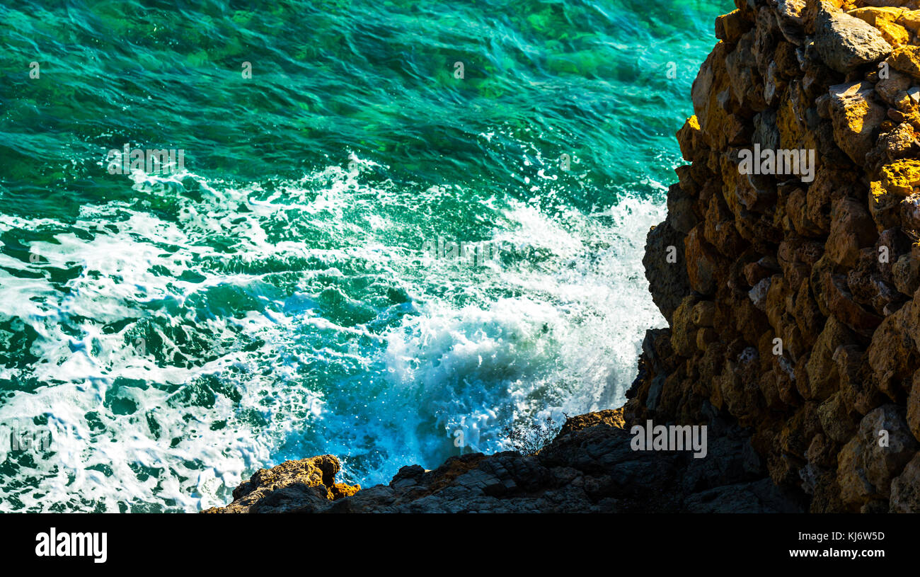high cliff above the sea, summer sea background, many splashing waves ...
