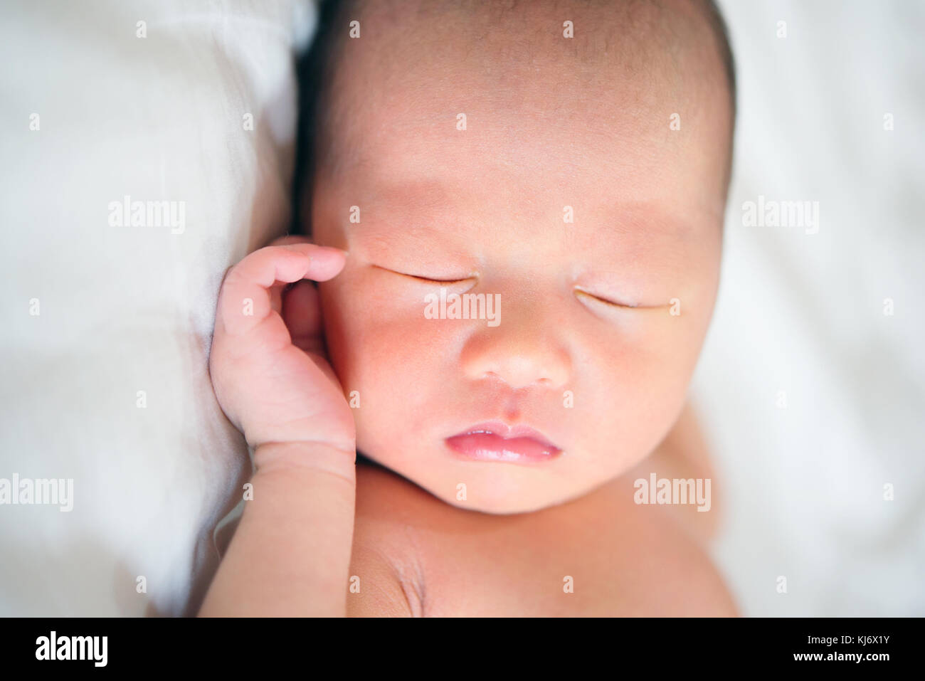 Asian newborn baby sleeping in bed Stock Photo - Alamy