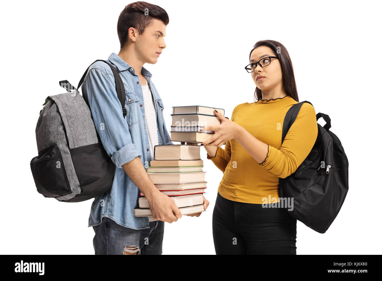 Female teen student giving a stack of books to a male teen student ...