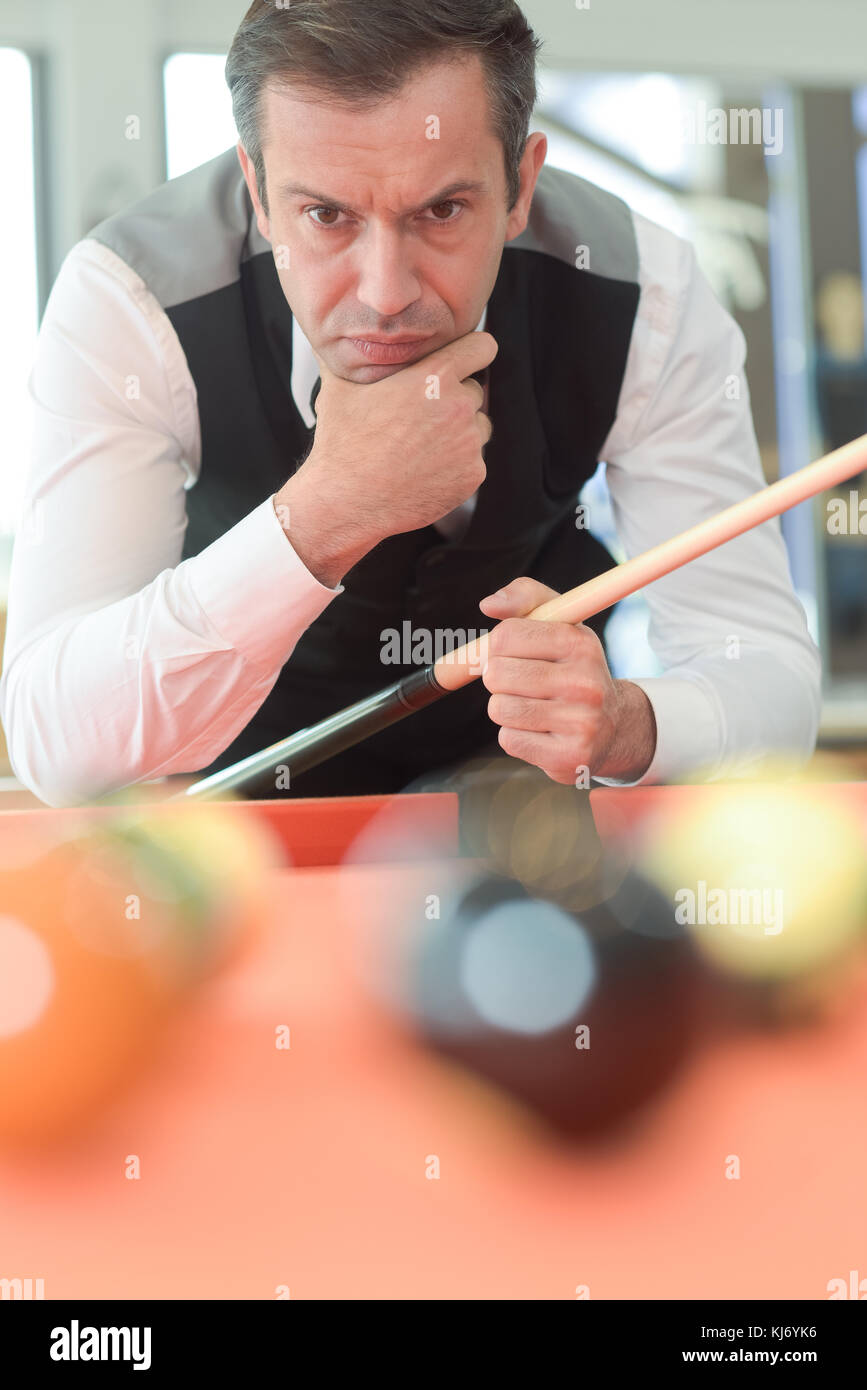 Man assessing balls on pool table Stock Photo - Alamy