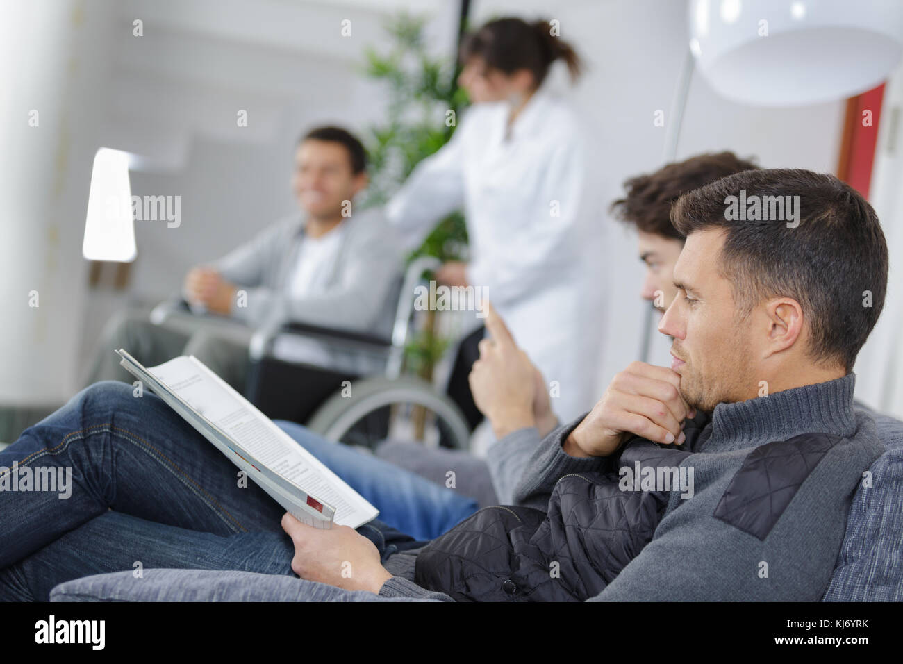 Men reading in hospital waiting room Stock Photo - Alamy