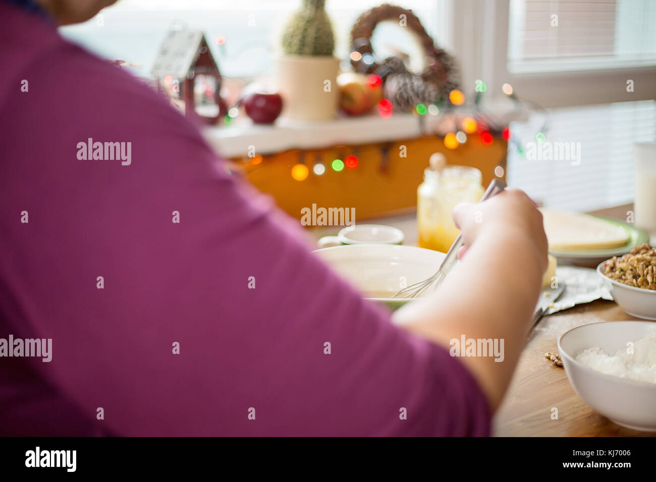 Close up photo of youn woman sitting behind the table in the kitchen ...