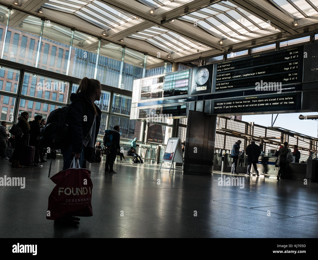 Passengers gaze at the timetable information display on the concourse ...