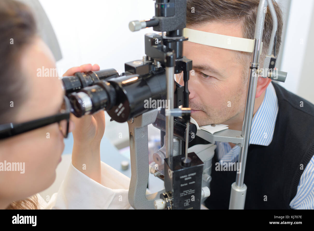 female optician in surgery giving man eye test Stock Photo - Alamy