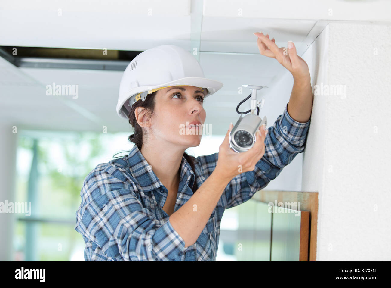pretty female installing cctv camera Stock Photo - Alamy