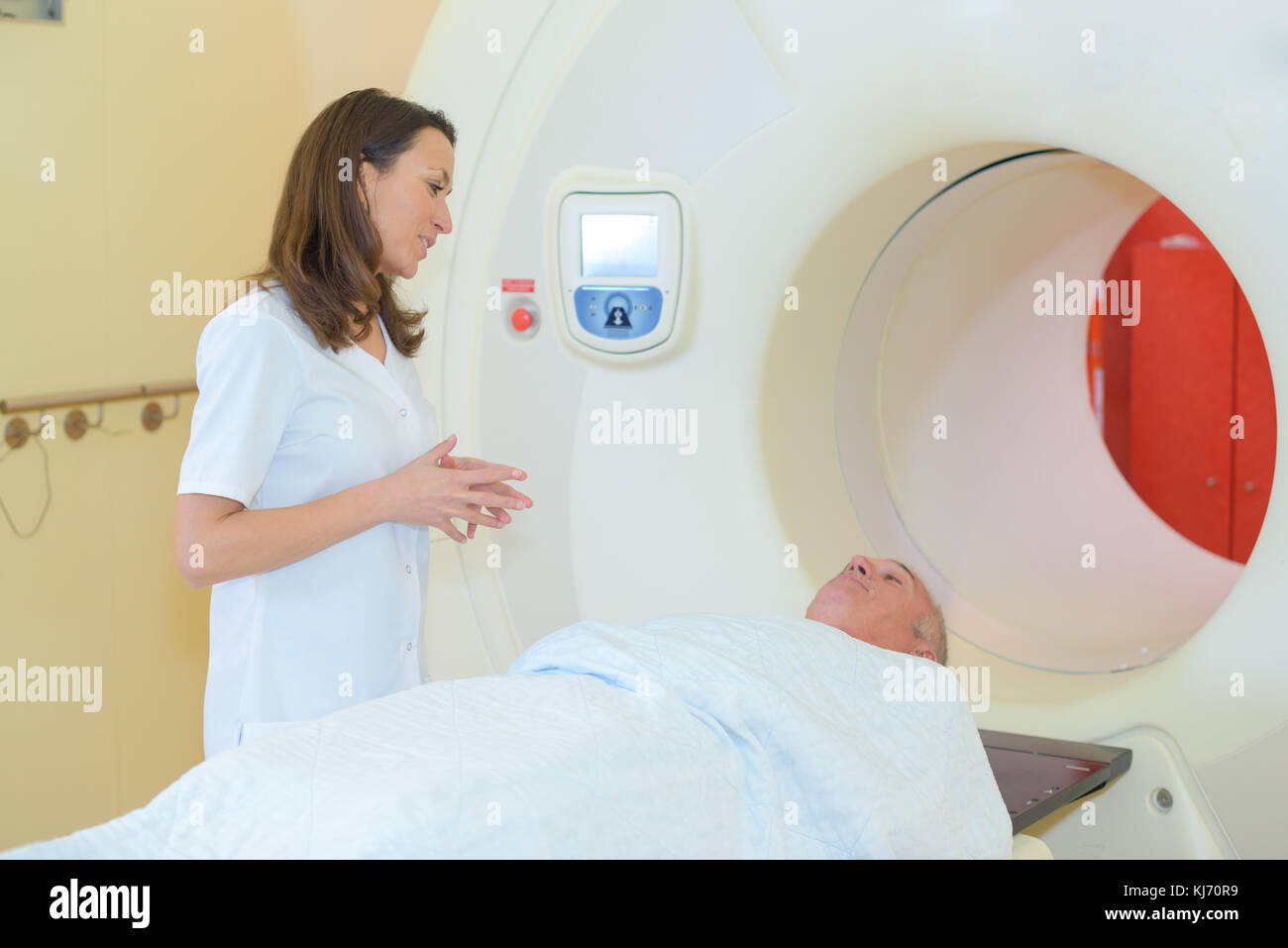 Nurse talking to man entering scanner Stock Photo - Alamy
