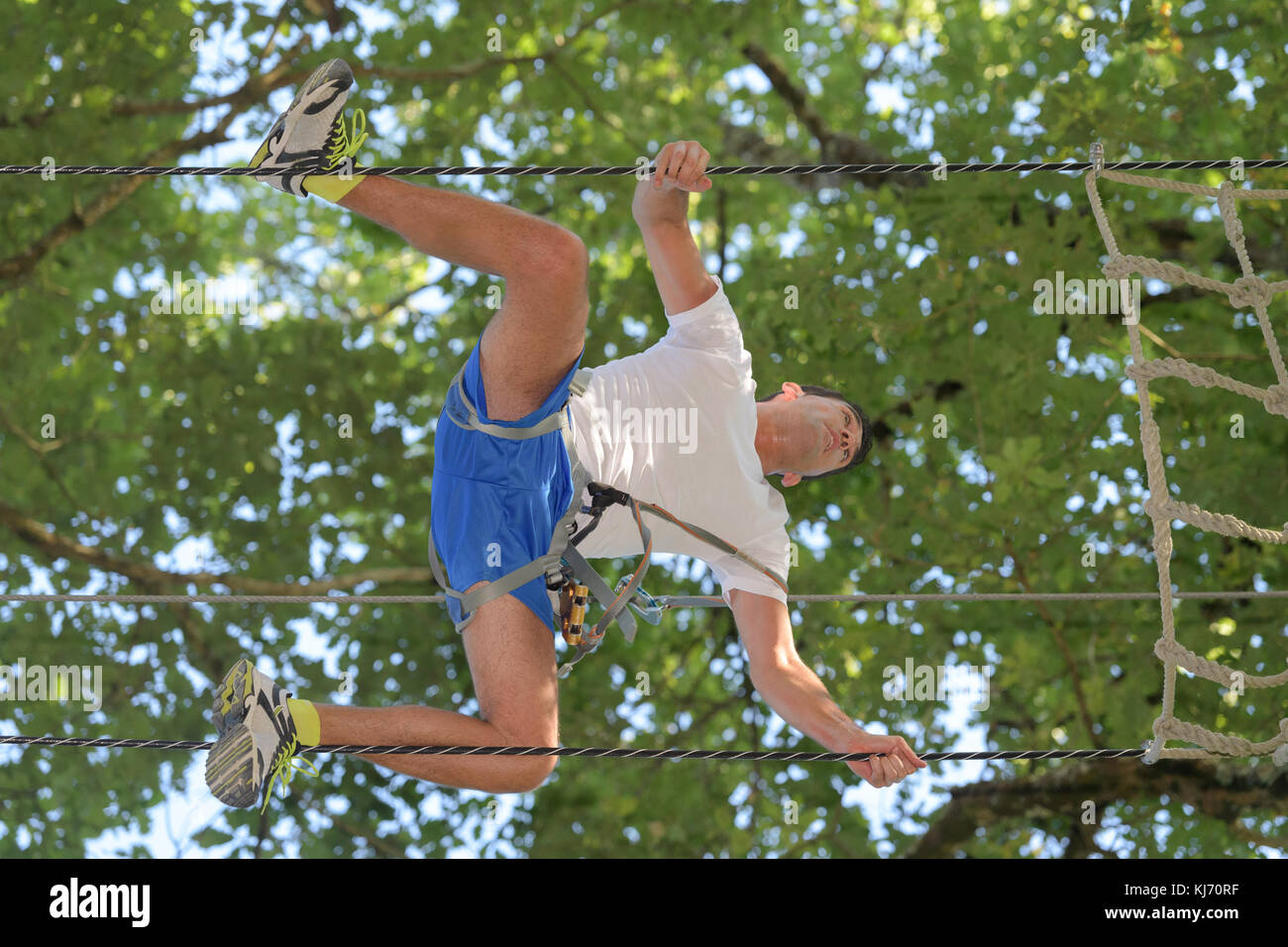 man climbing rope at the adventure park Stock Photo - Alamy