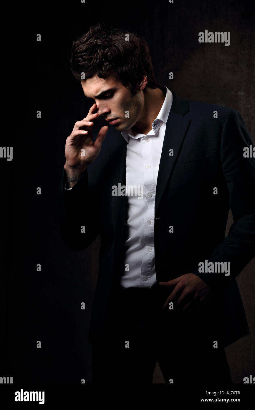 Thinking charismatic man posing and looking down on dark shadow ...