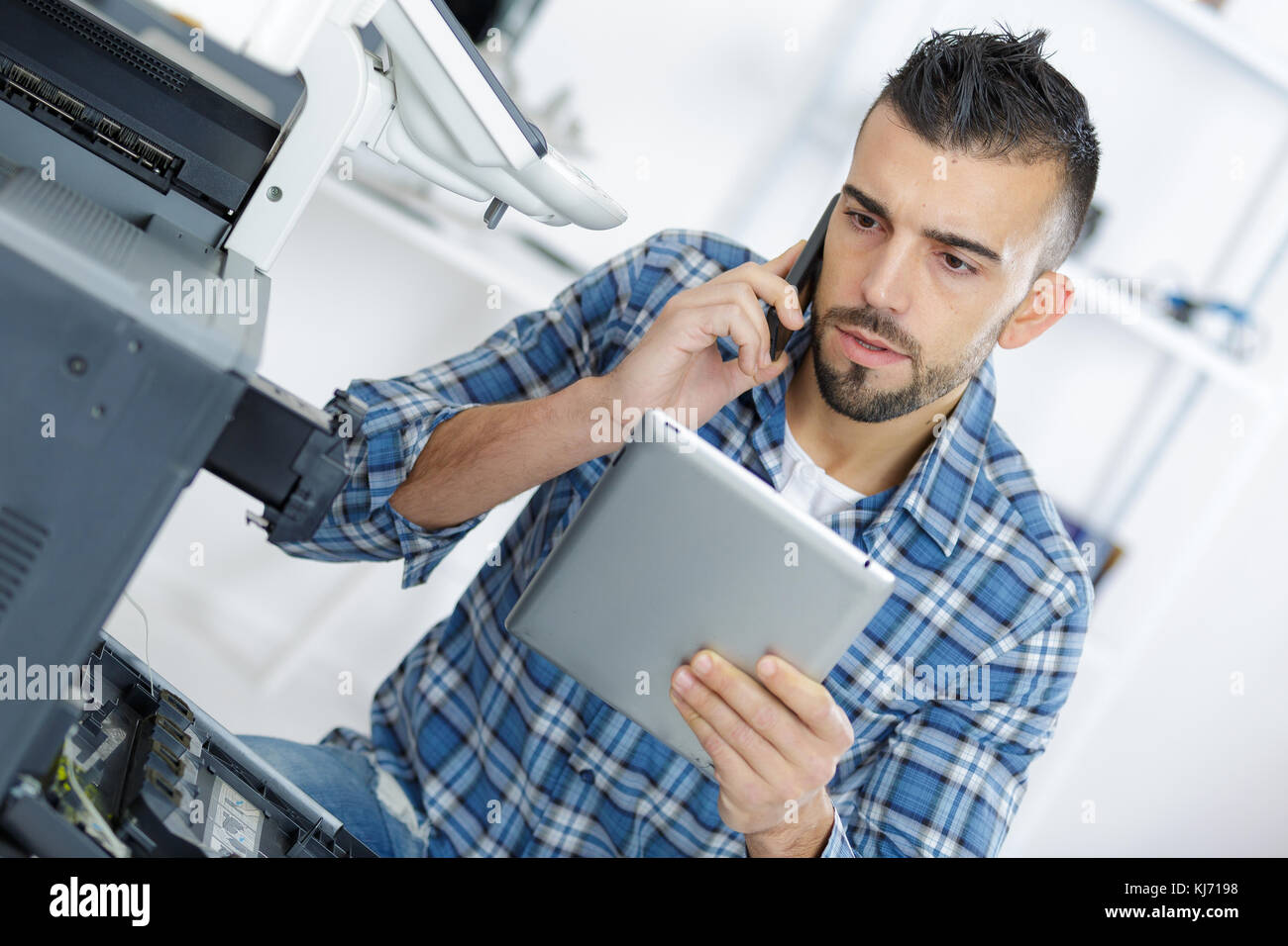 technician using his phone and laptop tablet Stock Photo - Alamy