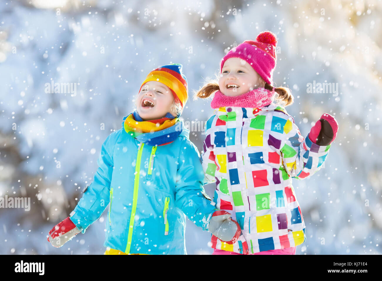 Kids playing in snow. Children play outdoors on snowy winter day. Boy ...