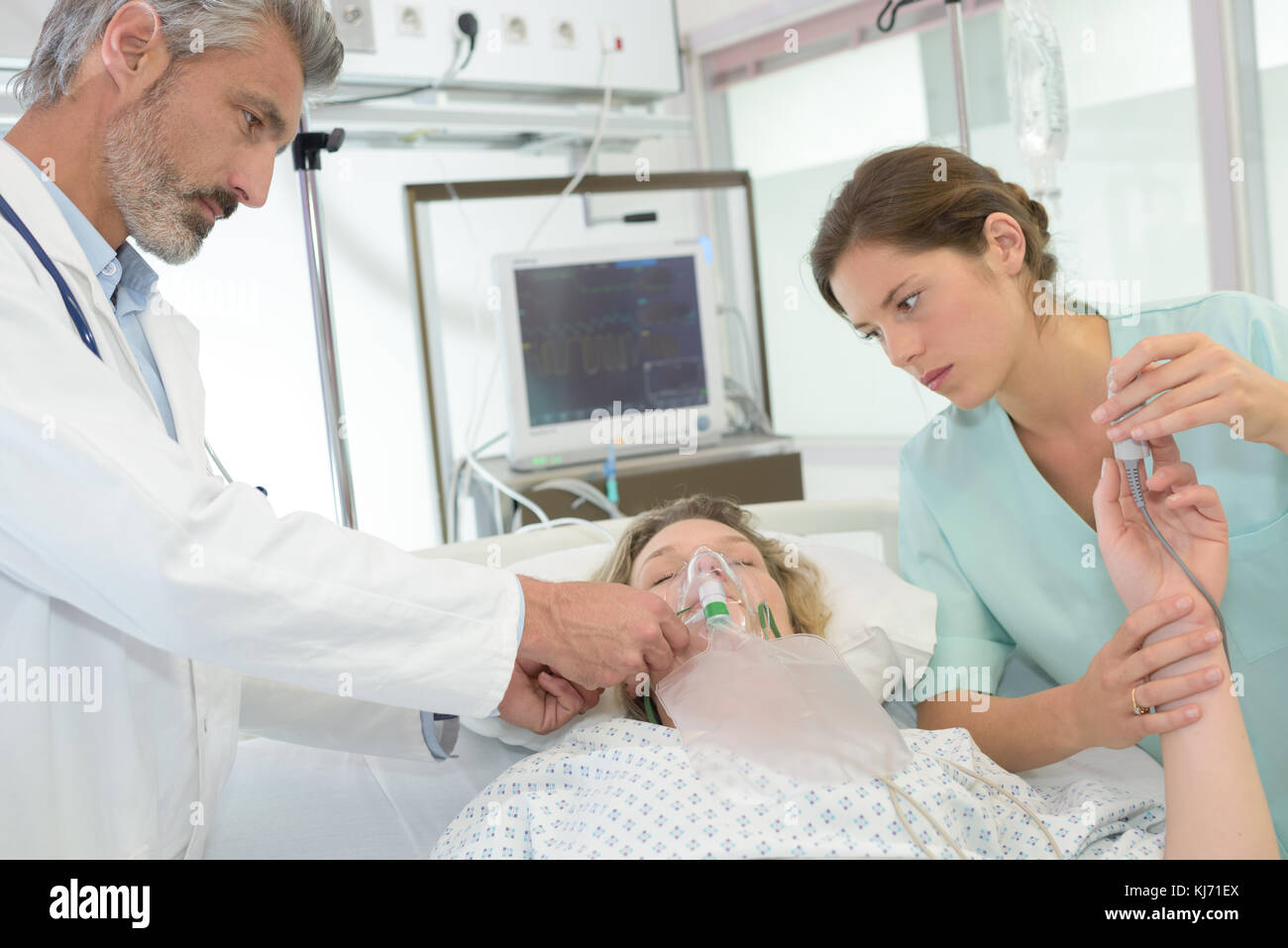 medical team attending to patient with mask and pulse reader Stock ...