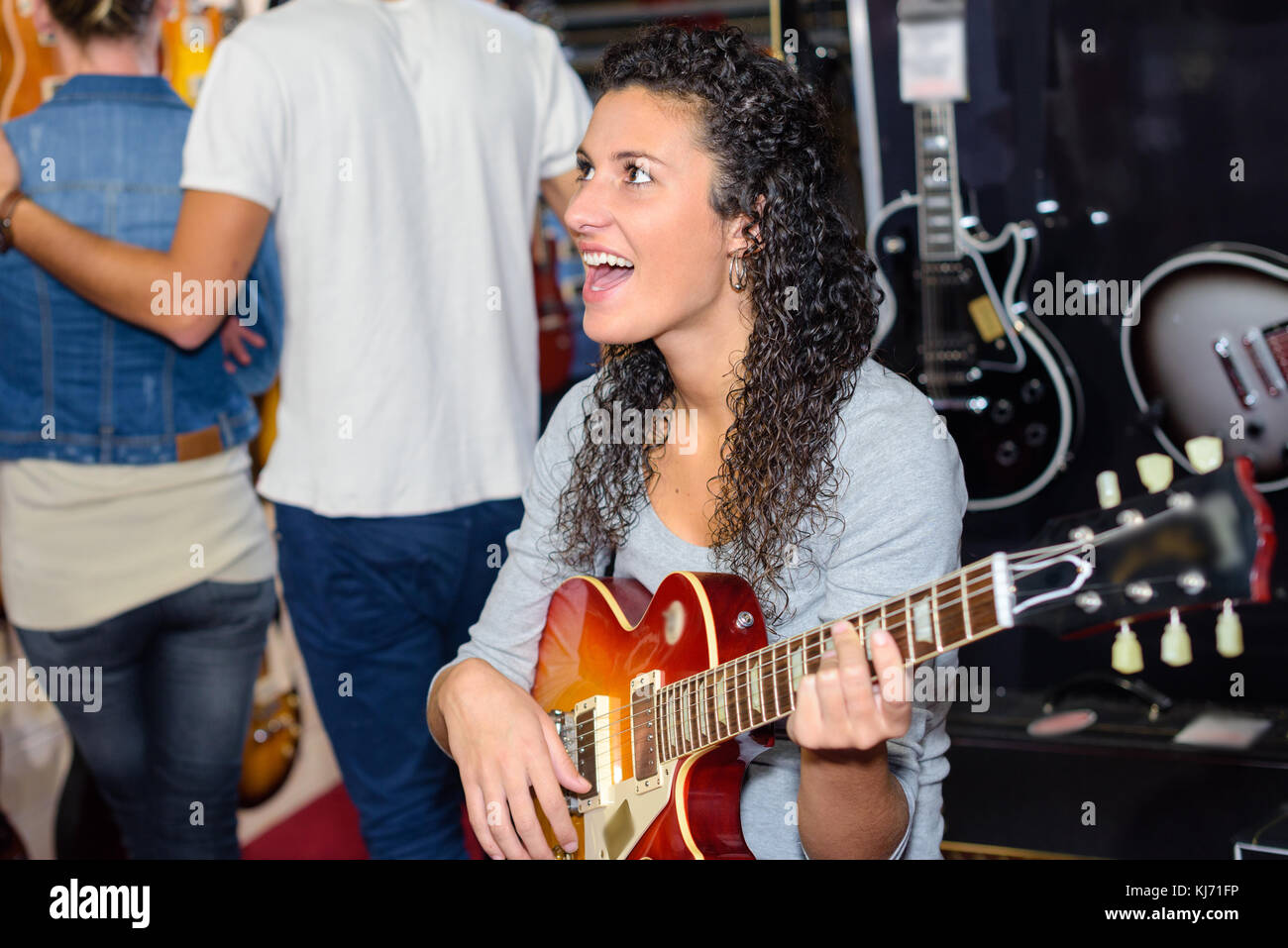 singing while playing a guitar Stock Photo - Alamy