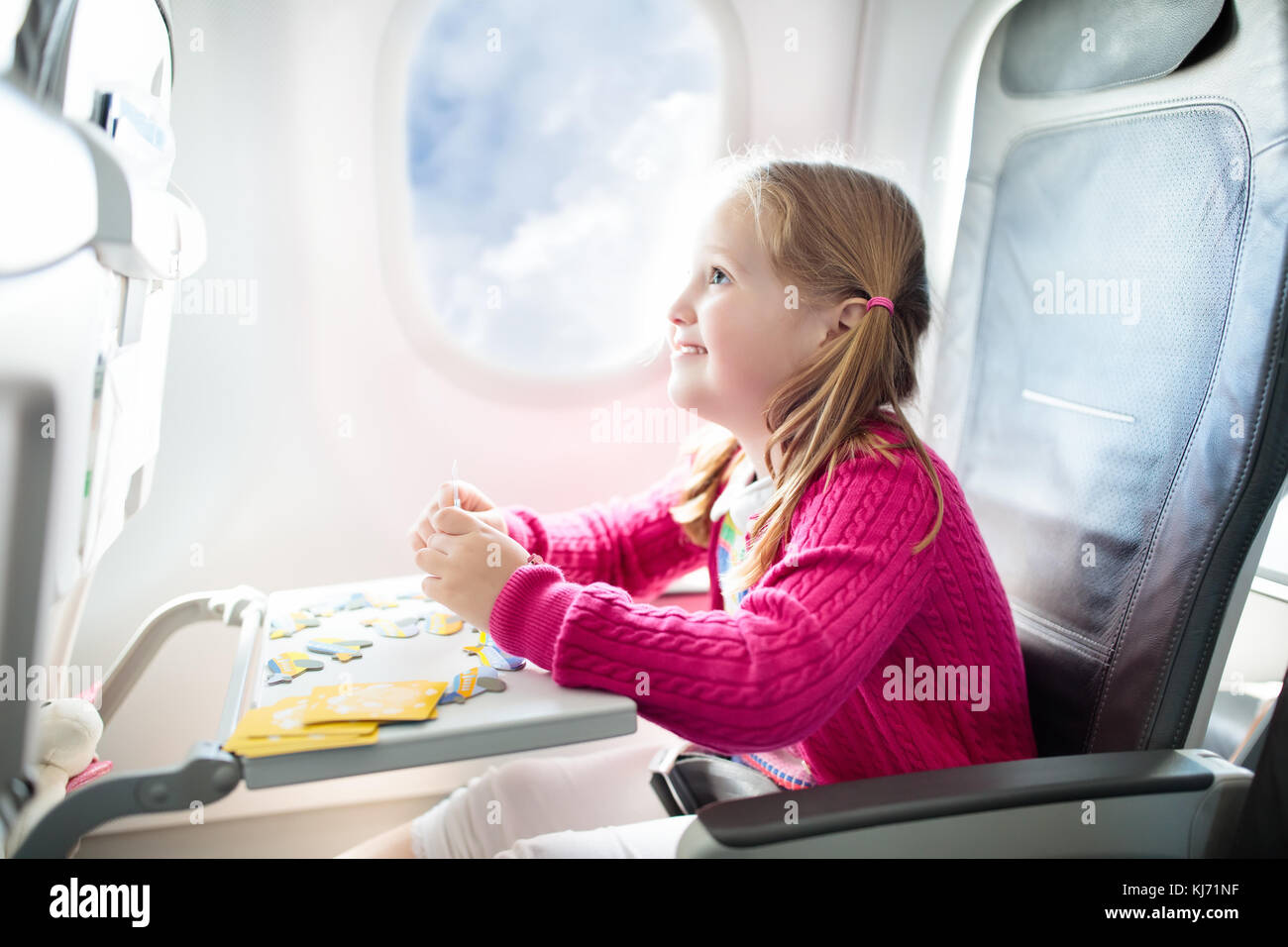 Child in airplane. Kid in air plane sitting in window seat. Flight ...