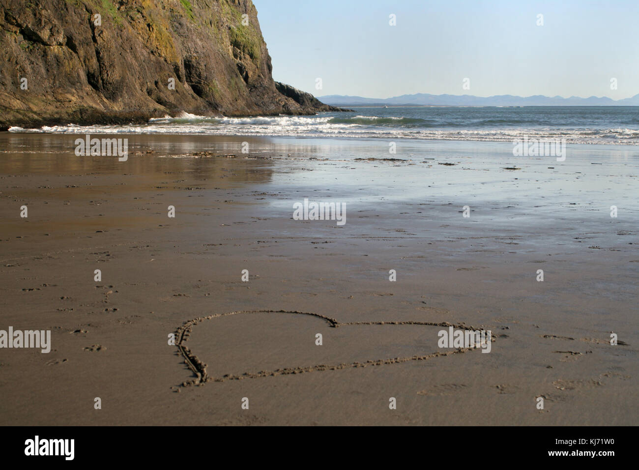 Heart shape drawn out in the sand on the beach Stock Photo - Alamy