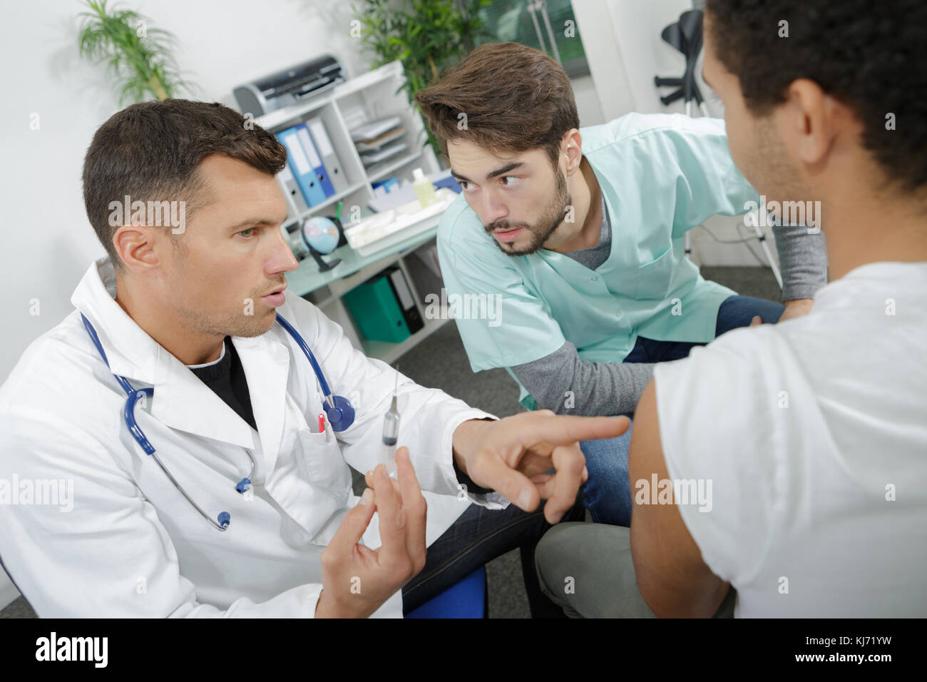 doctor showing healthcare worker how to do an injection Stock Photo - Alamy