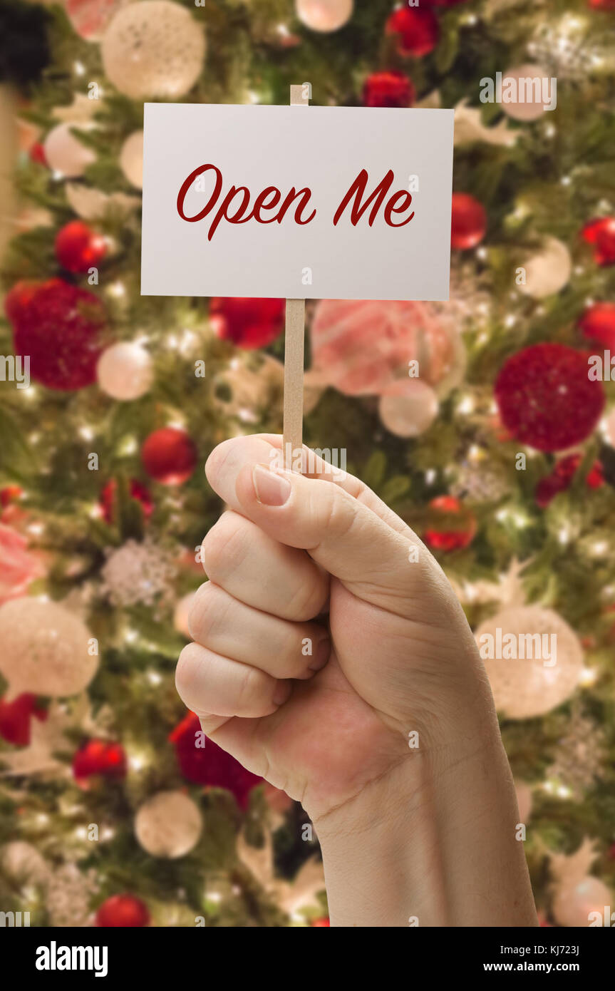 Hand Holding Open Me Card In Front of Decorated Christmas Tree Stock ...