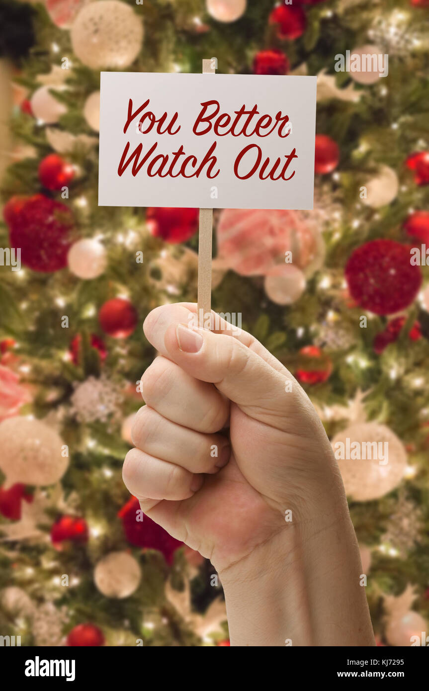 Hand Holding You Better Watch Out Card In Front of Decorated Christmas ...