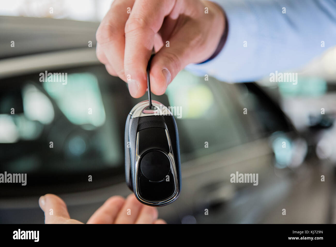 close up photo of male hand giving car keys to female hand, indoors in ...
