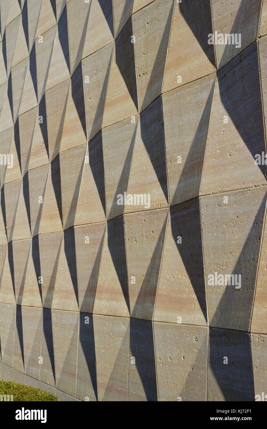 Geometric patterned concrete wall has diamond shapes accented with ...