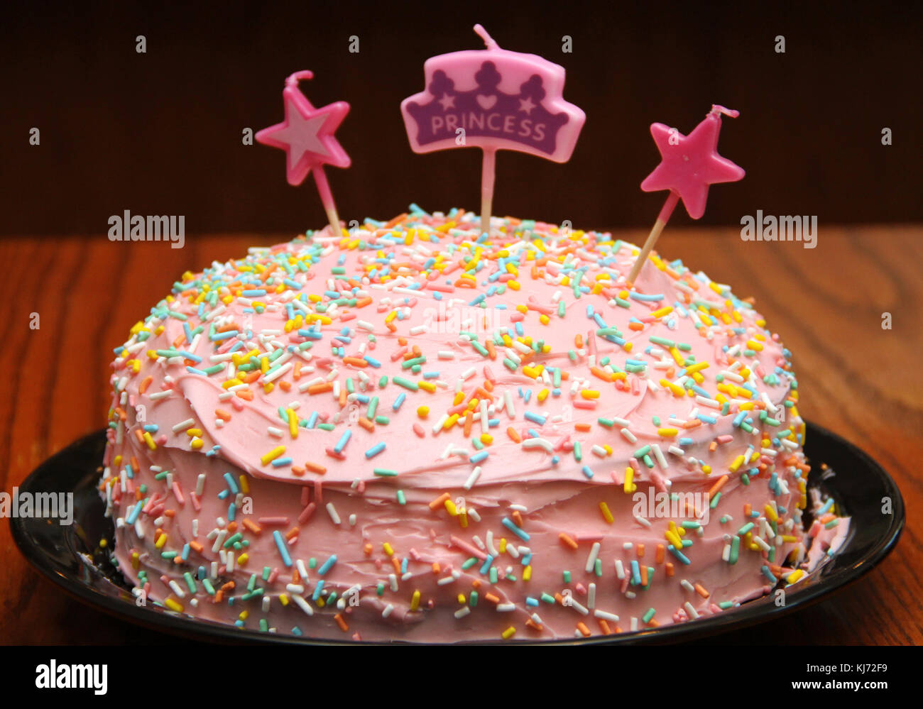 A pink birthday cake with lots and lots of sprinkles for a princess ...