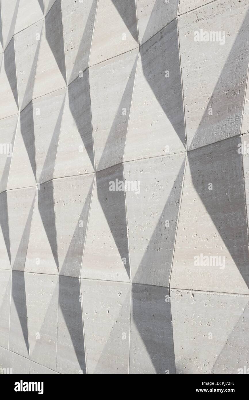 Geometric patterned concrete wall has diamond shapes accented with ...