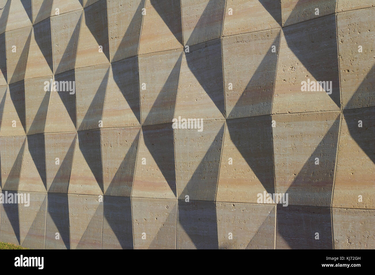 Geometric patterned concrete wall has diamond shapes accented with ...