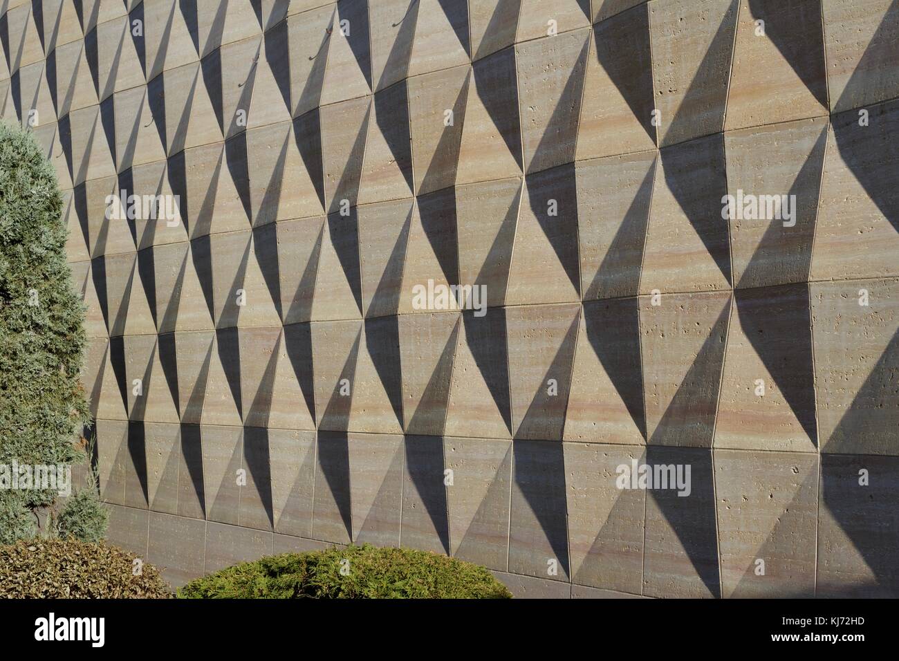 Geometric patterned concrete wall has diamond shapes accented with ...