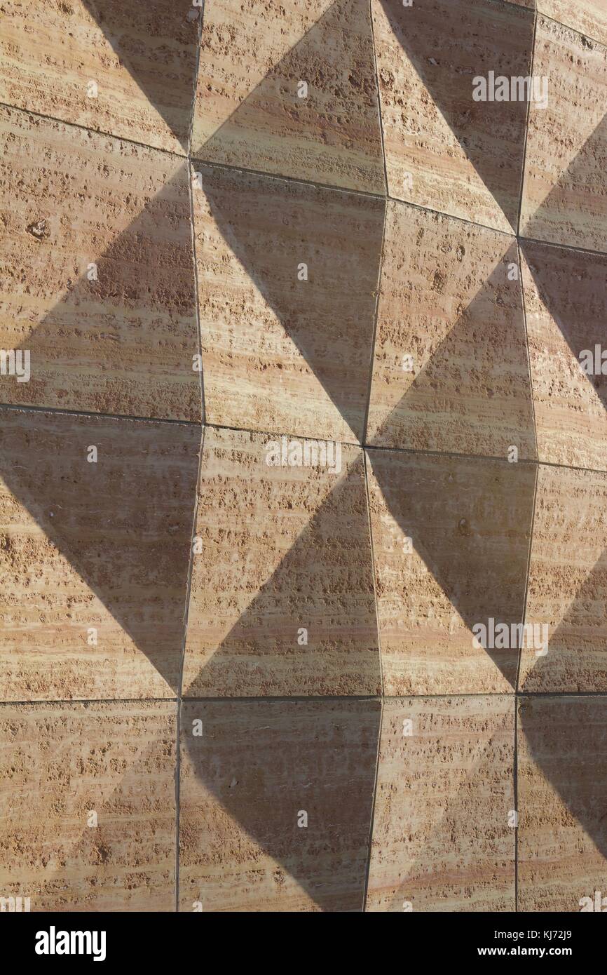 Geometric patterned concrete wall has diamond shapes accented with ...