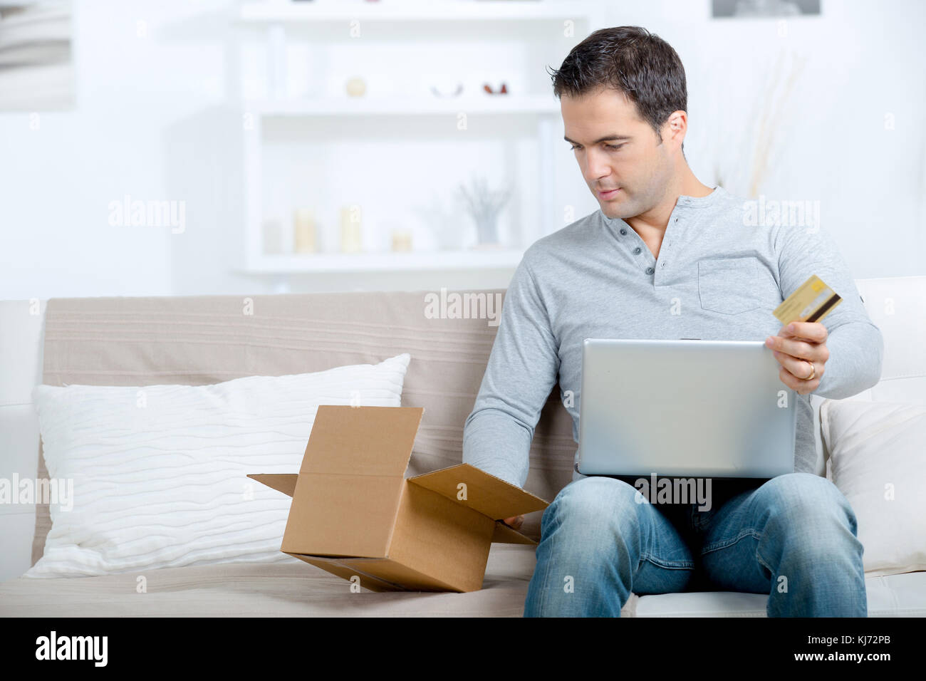 man with laptop credit card and cardboard boxes at home Stock Photo - Alamy